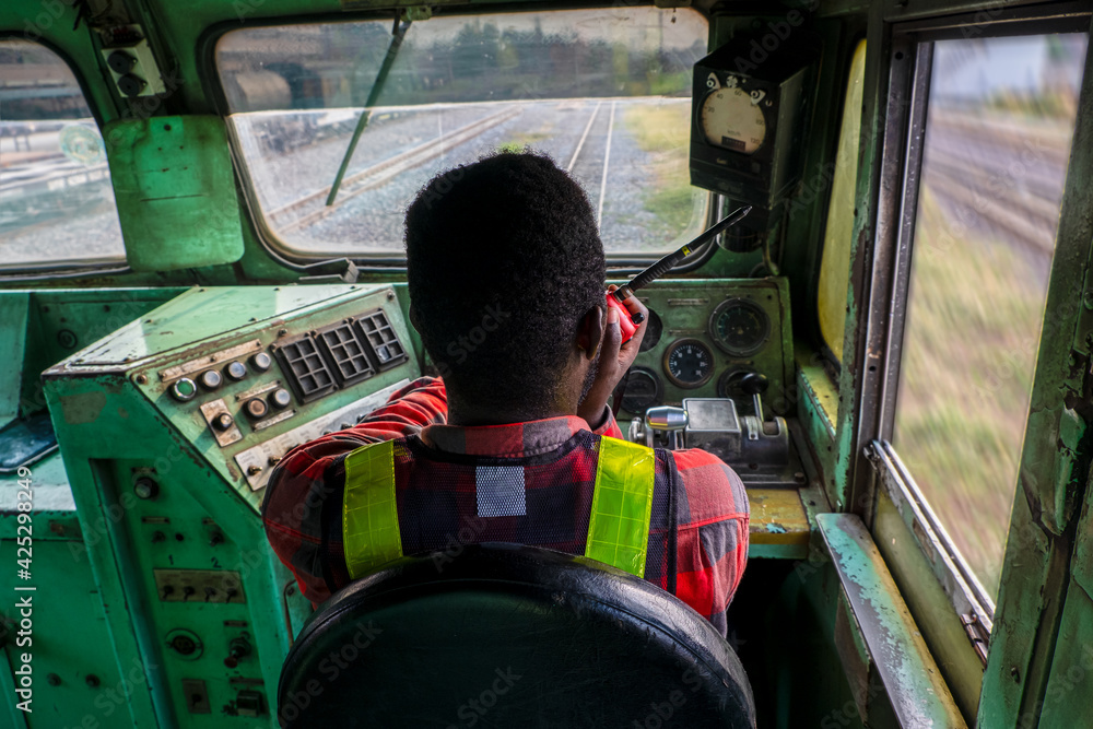 African man train driver sitting interior to control place of train ...