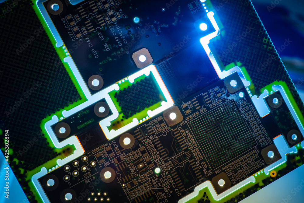Circuit board close-up. Dark PCB glows in dark. Background consists of ...