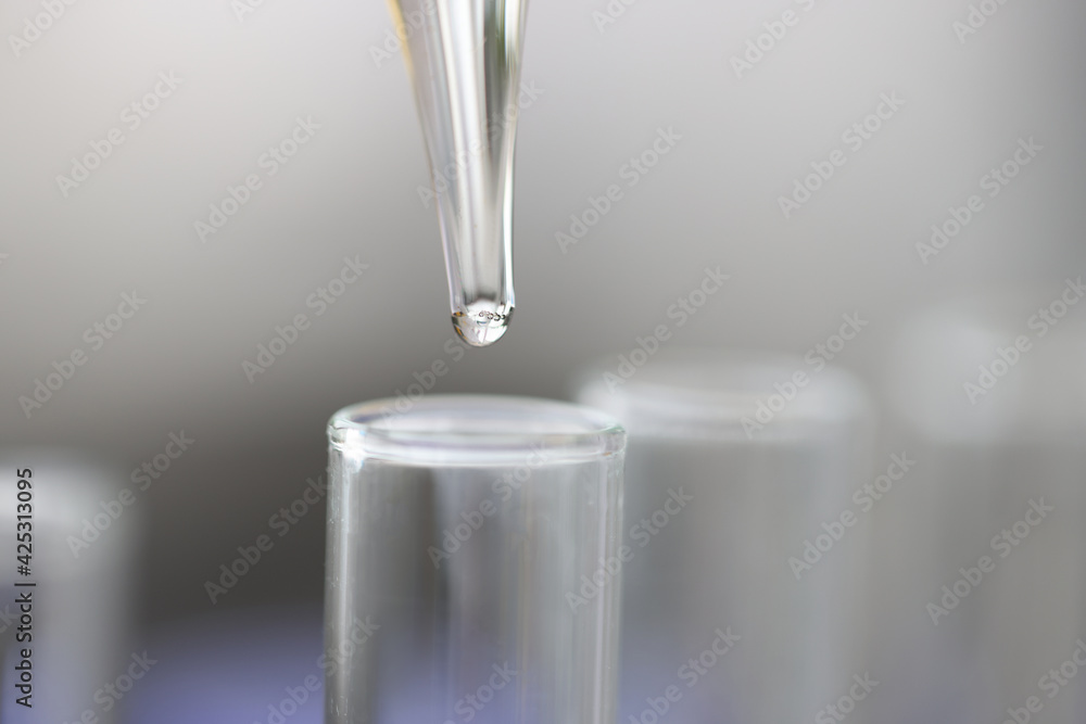 Clear liquid drips from pipette into test tube Stock Photo | Adobe Stock