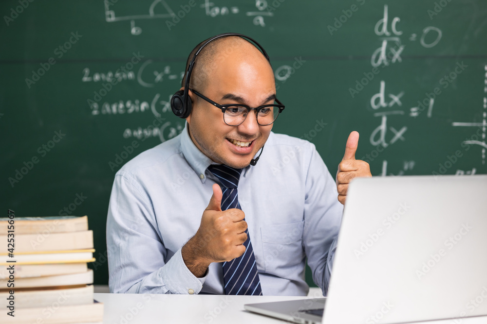 Indian young teacher man sitting wearing headset teaching online video ...
