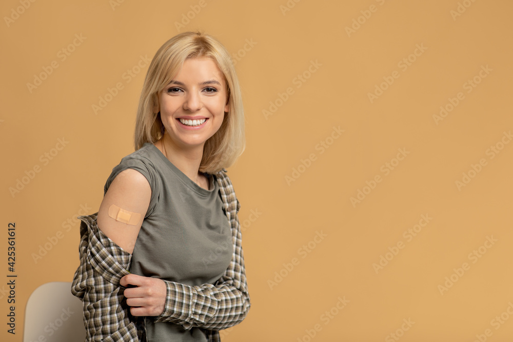 Virus protection. Excited vaccinated woman showing arm after injection ...