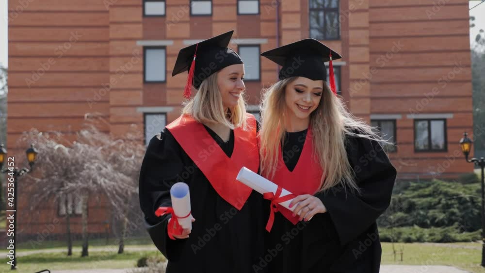 Two charming blonde girls go to the graduation ceremony laughing ...