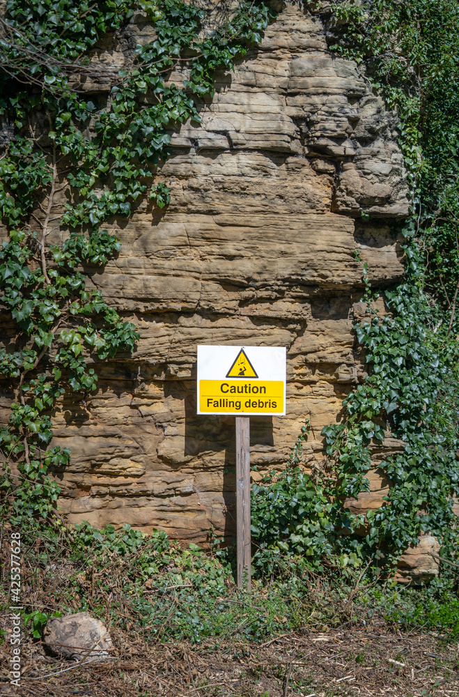 Beware of falling rock warning sign with triangle picture and alert ...