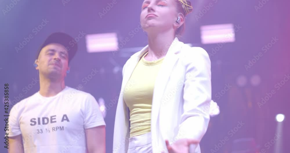 Singing girl, side view of girl singer in stage lights Young stylish ...