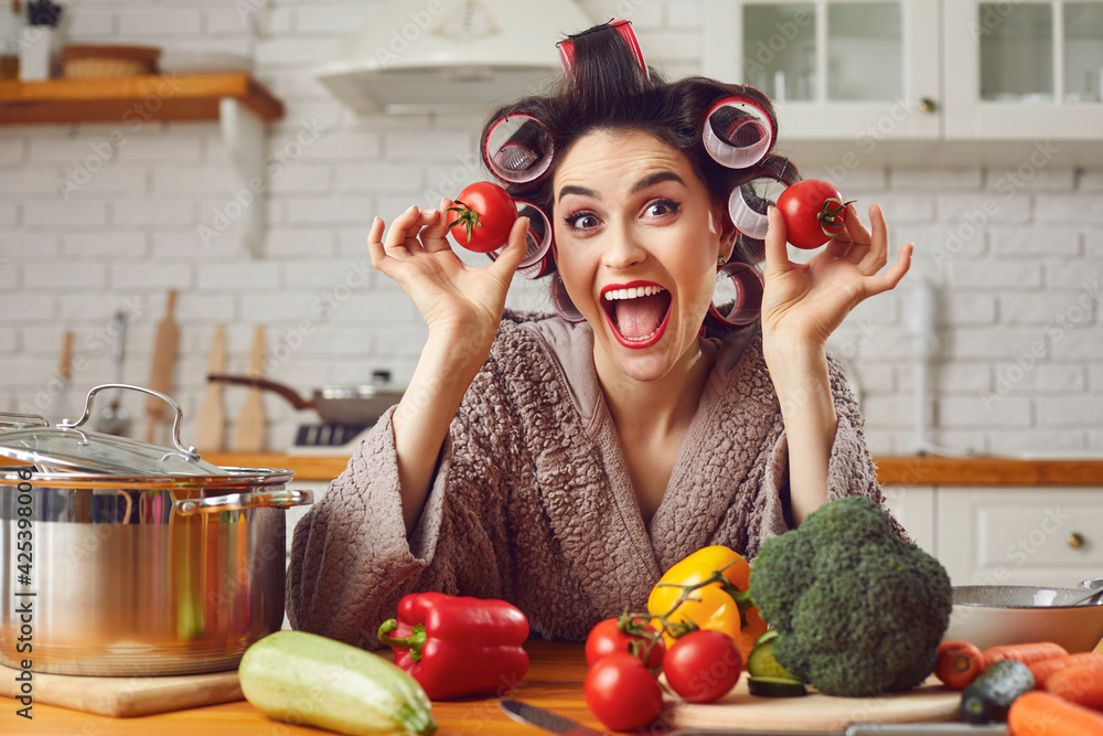 Funny cheerful young woman cooking vegetarian meal, fooling around ...