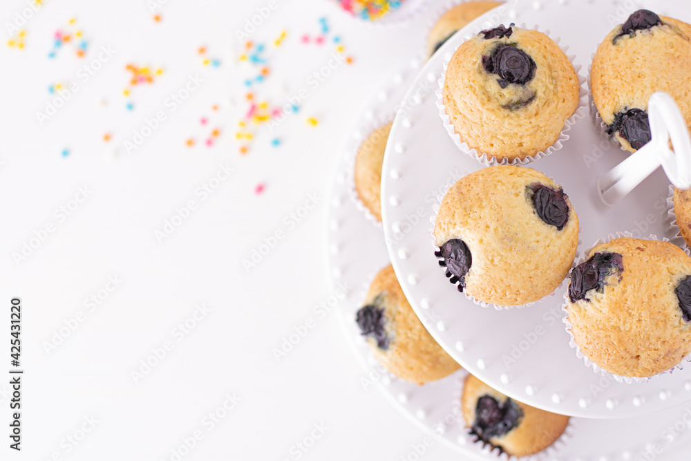 Muffins presented on a double-decker tray, top view, white background ...