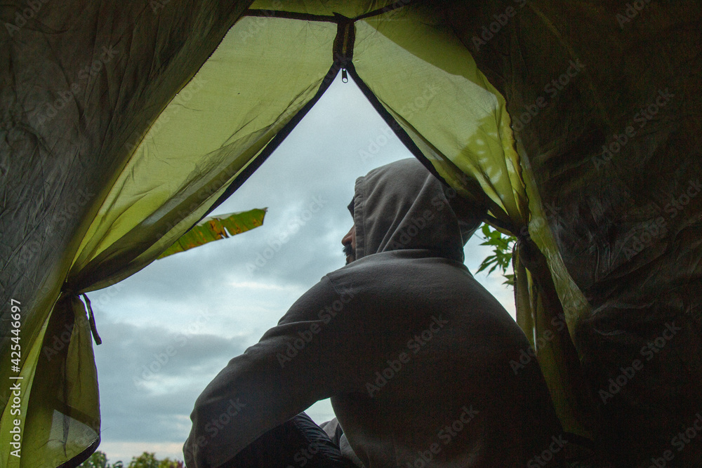 Hombre acampando en una carpa o tienda de campaña viendo el paisaje de ...