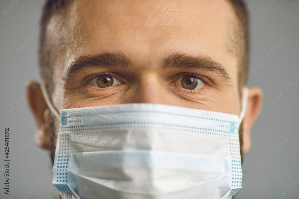 Closeup studio portrait of caucasian man in face medical mask with wide ...
