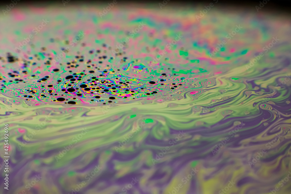 The colorful close-up surface of a soap bubble with weird psychedelic ...