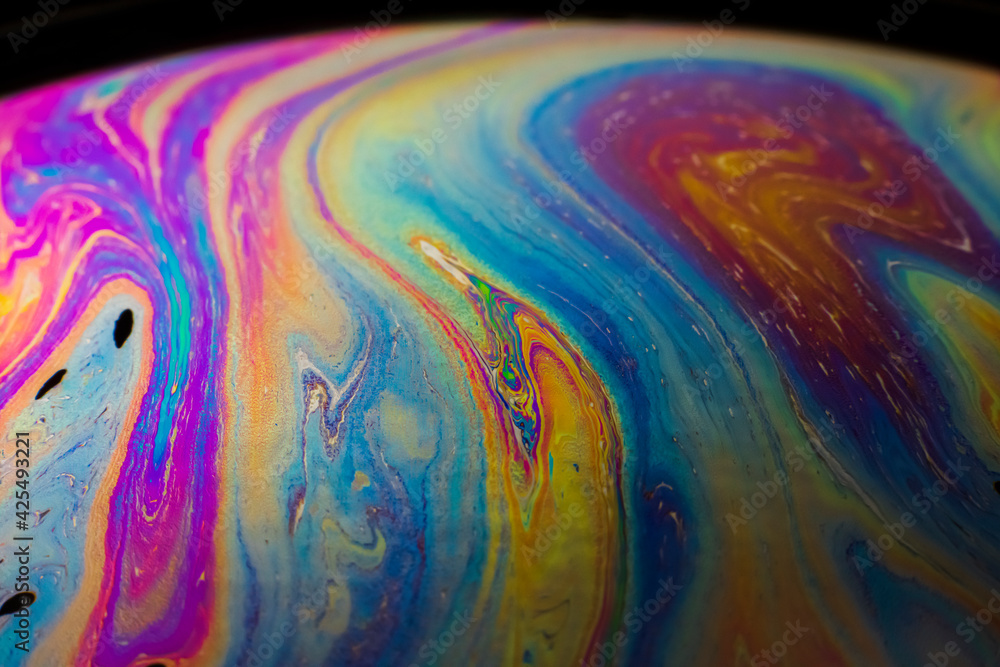 The colorful close-up surface of a soap bubble with weird psychedelic ...