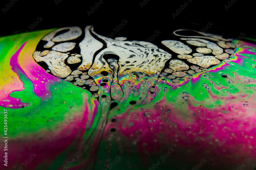 The colorful close-up surface of a soap bubble with weird psychedelic ...