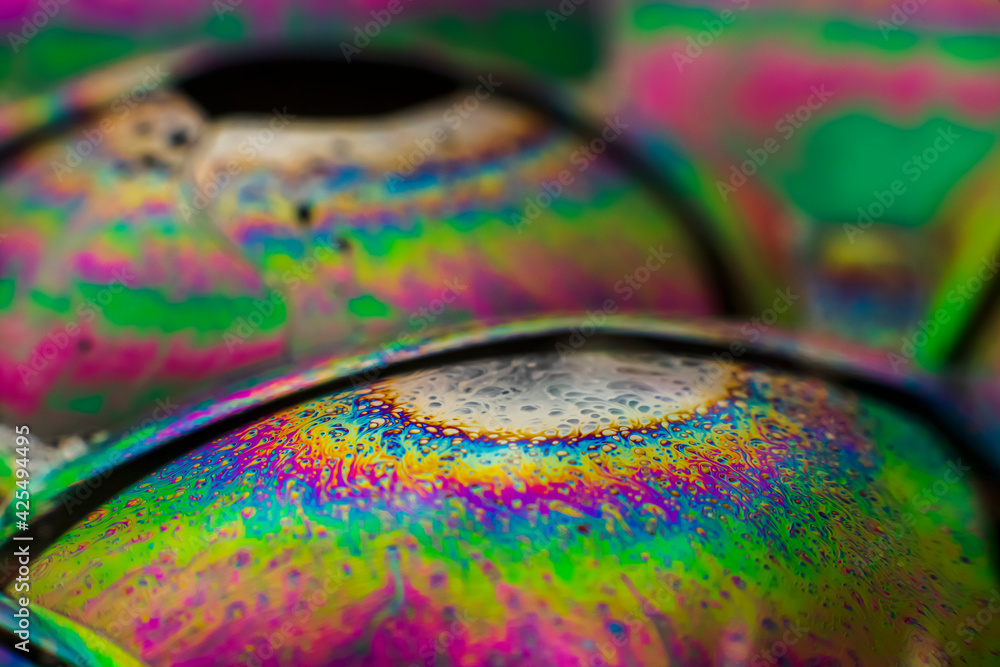 The colorful close-up surface of a soap bubble with weird psychedelic ...