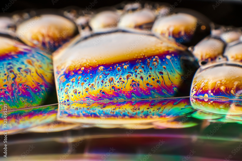 The colorful close-up surface of a soap bubble with weird psychedelic ...