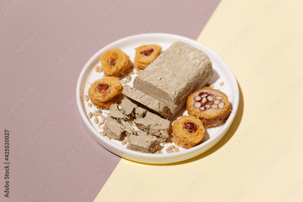 Sunflower halva on a colored background. Traditional oriental sweets. Jewish, Turkish, Arabic ...