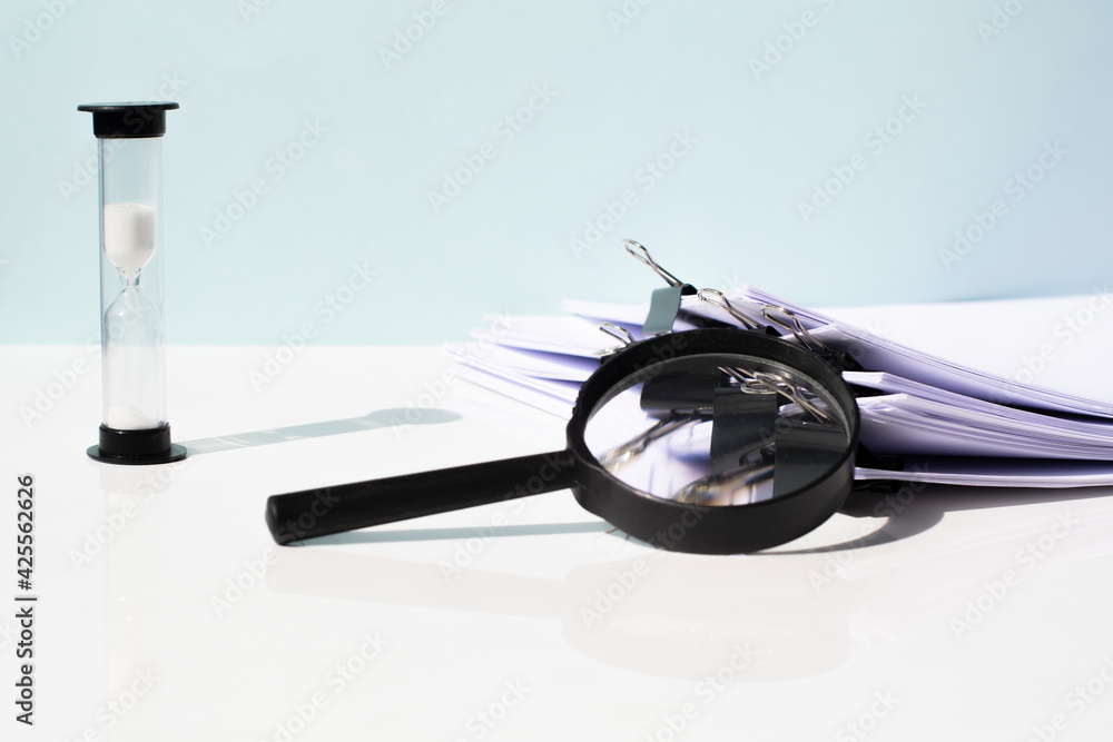 Scanning business documents. Magnifying glass on the stack of documents ...