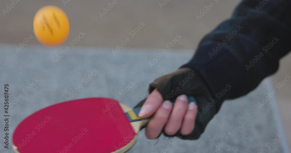 Close up of a young man balancing a ping pong ball on his ping pong bat ...