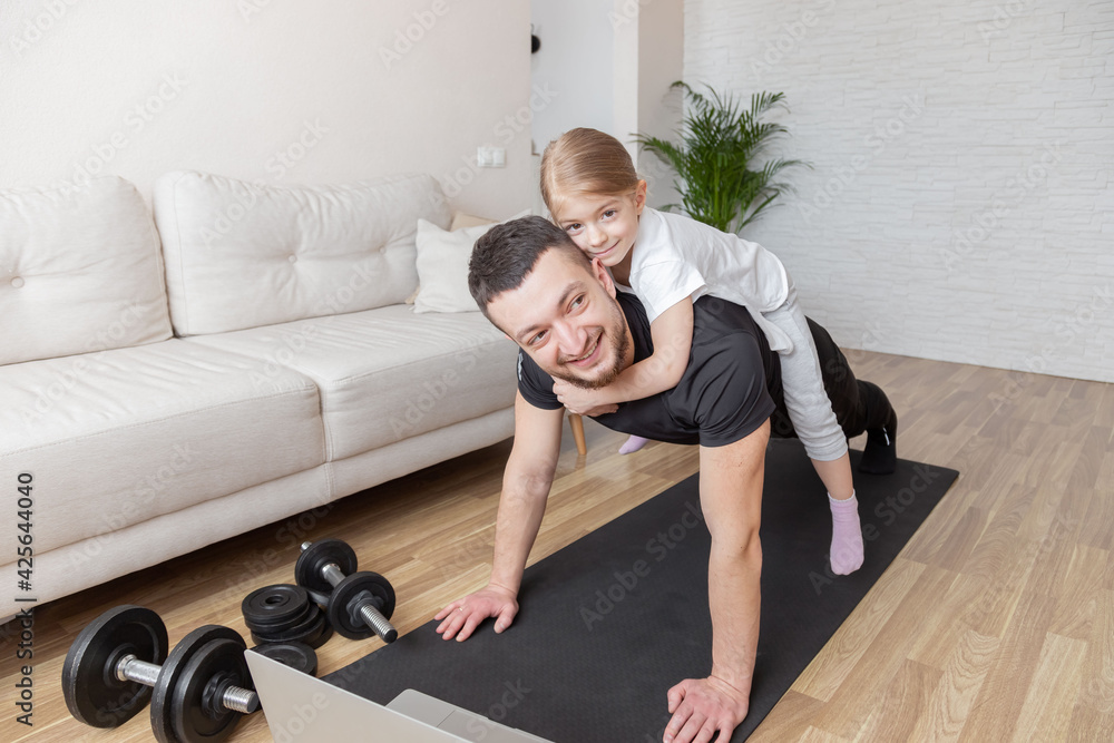 Foto de Active father and his young daughter are training at home. Man ...
