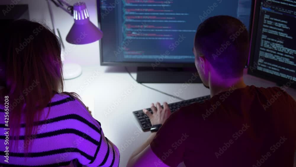 Two smart young programmers are coding on computer in process of ...