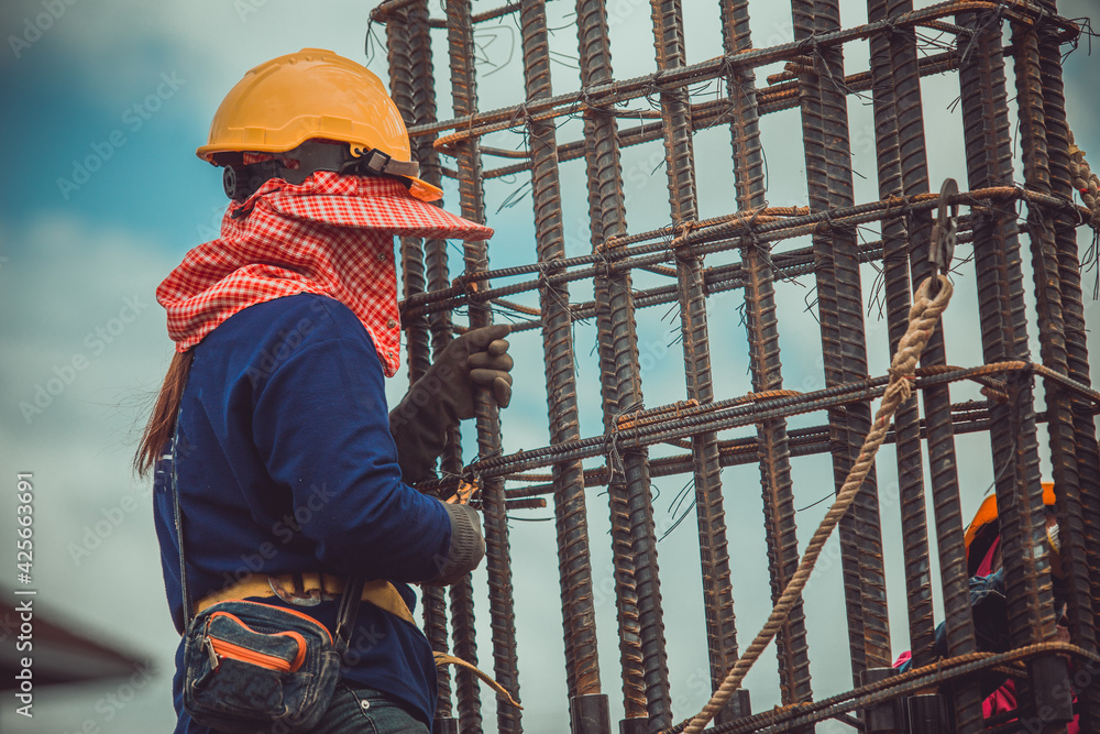 Female laborers are climbing on the scaffolding to assemble the steel ...