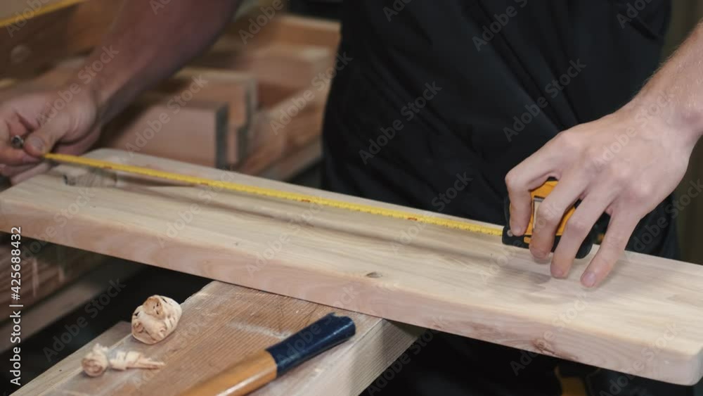 Carpenter with ruler measuring plank at workshop Stock Video | Adobe Stock