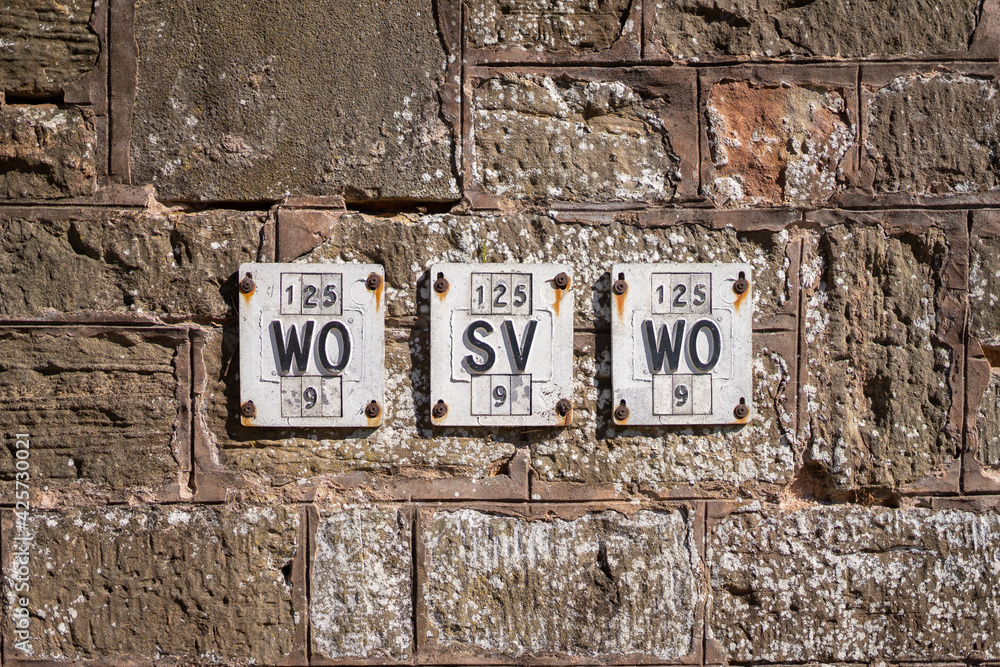 Row of ancient old English Victorian iron fire hydrant sign plaques on ...