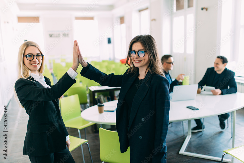 members of the business team giving each other a high five in frong of ...