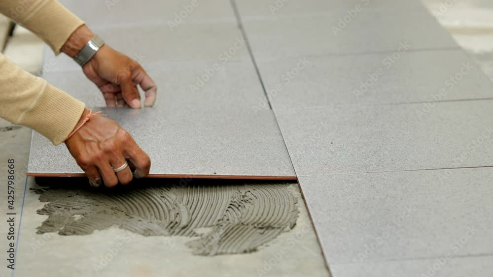 Worker Installing ceramic floor tiles in construction site Stock Video ...