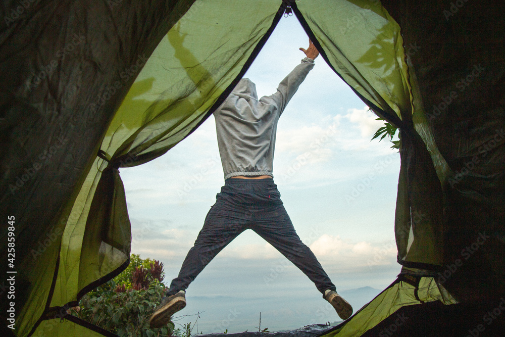 Hombre acampando en una carpa y dando un salto de alegría fuera de su ...