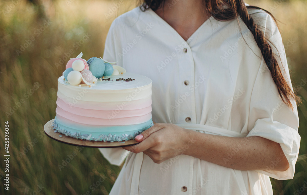 cake in female hands close-up. a woman in a white dress is holding a ...