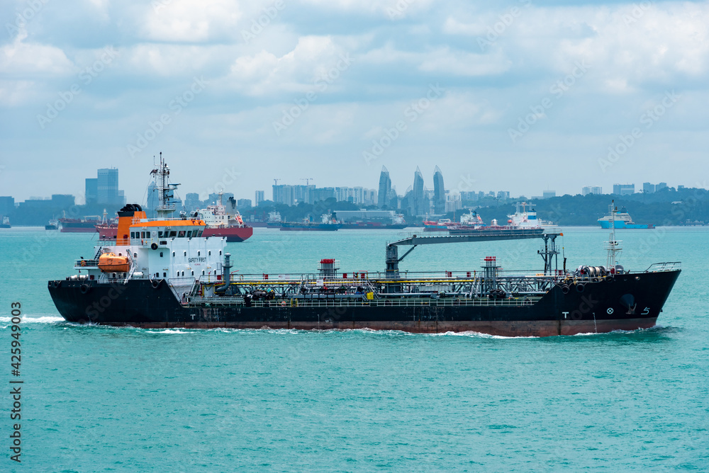 Small oil tanker ship (bunker barge) sailing near port of Singapore ...