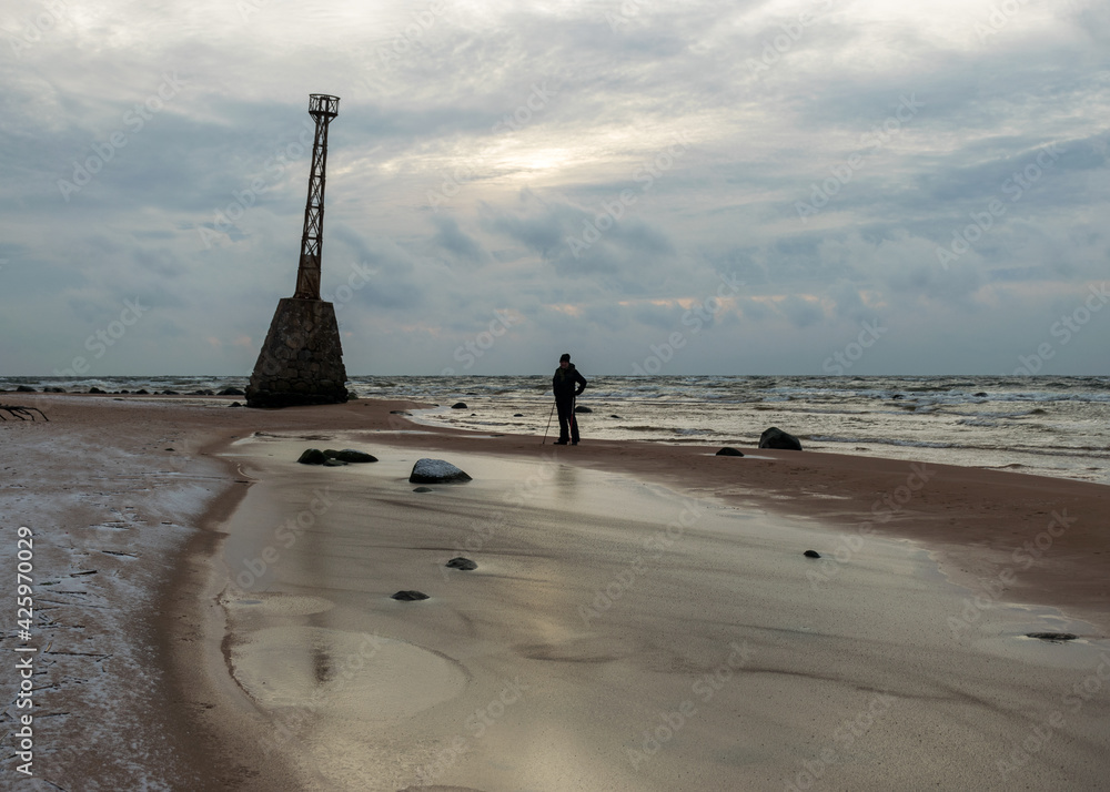 Lighthouse ruins. human silhouette by the sea, Wild beach Baltic coast ...