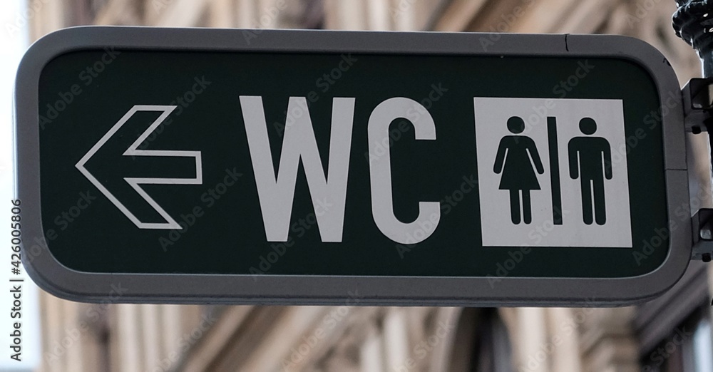 WC sign, logo of public toilets in the street against building ...