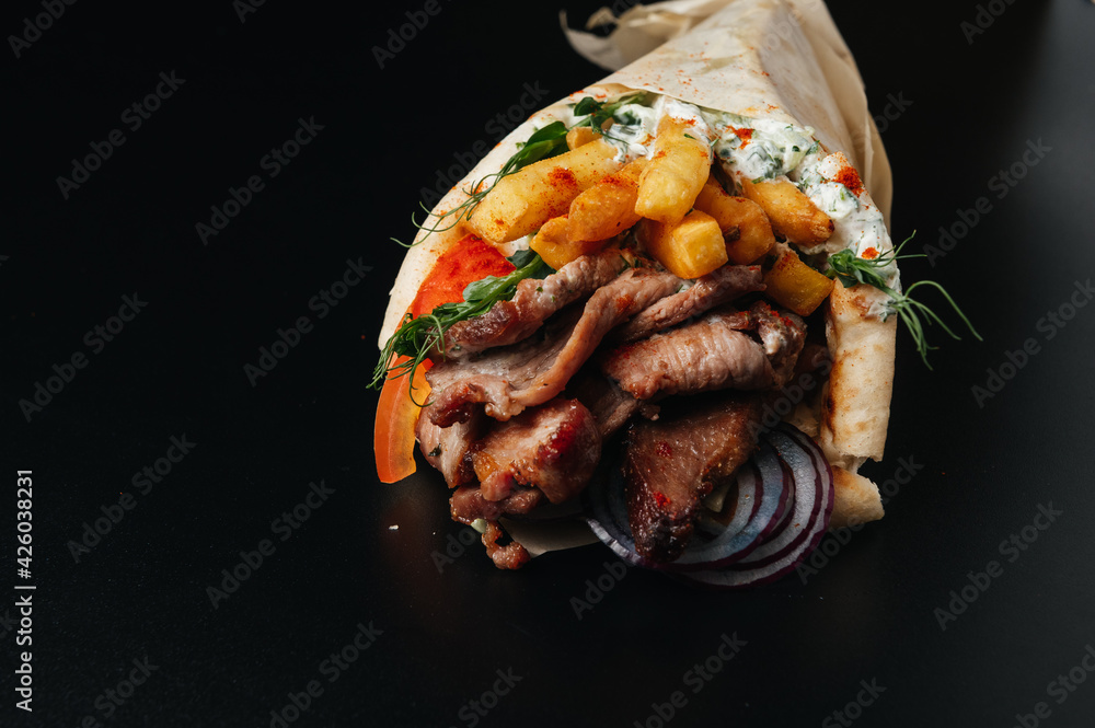 Greek gyros wrapped in pita breads on black background. Gyro pita ...