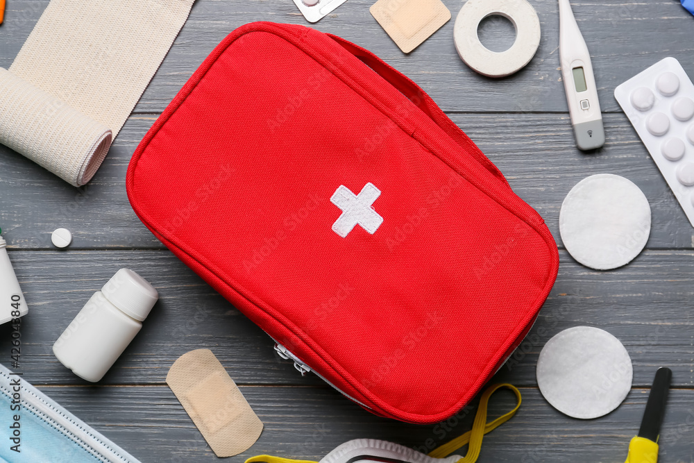 First aid kit on dark wooden background Stock Photo | Adobe Stock