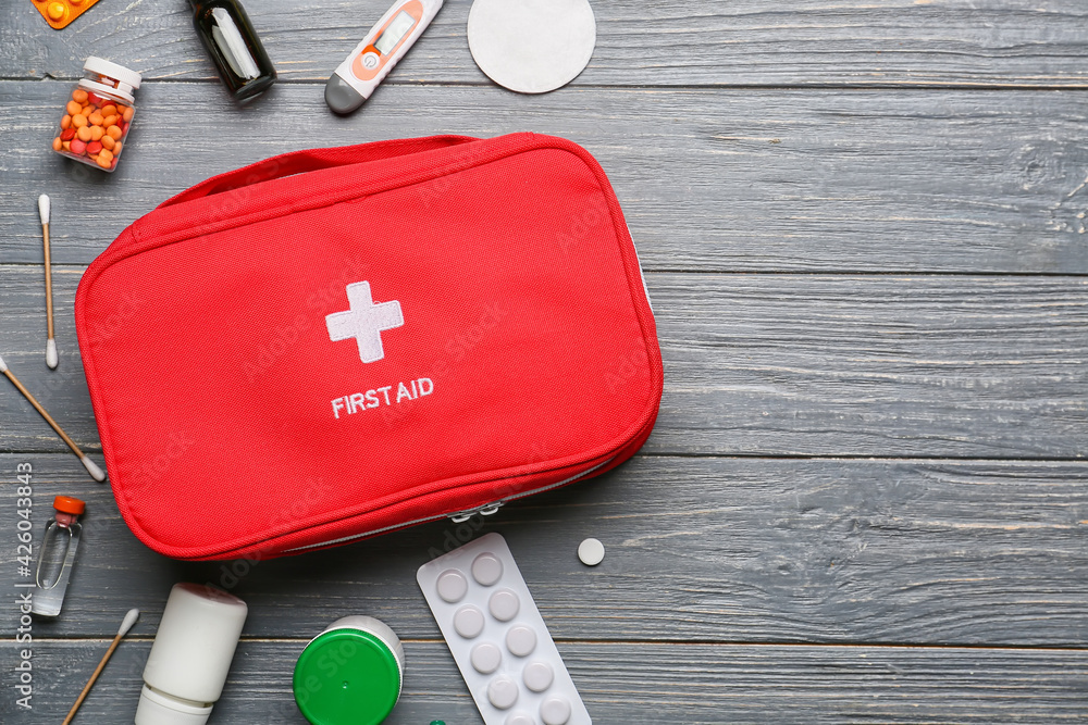 First aid kit on dark wooden background Stock Photo | Adobe Stock