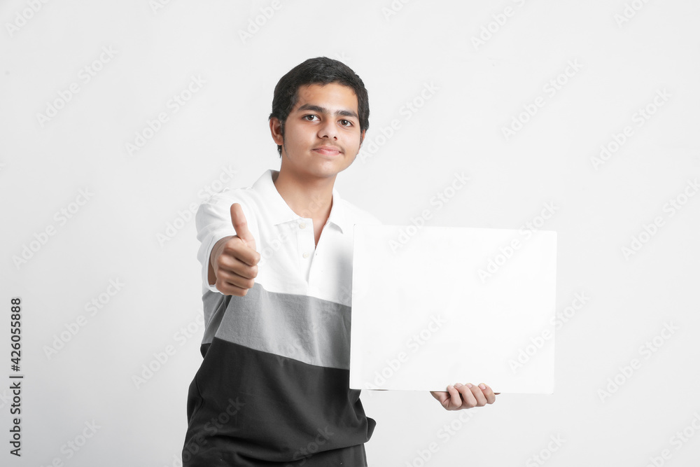 Young indian college student showing white board on white background ...
