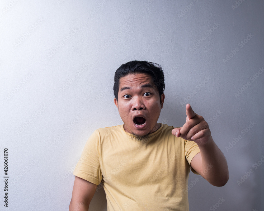Portrait of Young Asian man with face expression, shocked, pointing ...