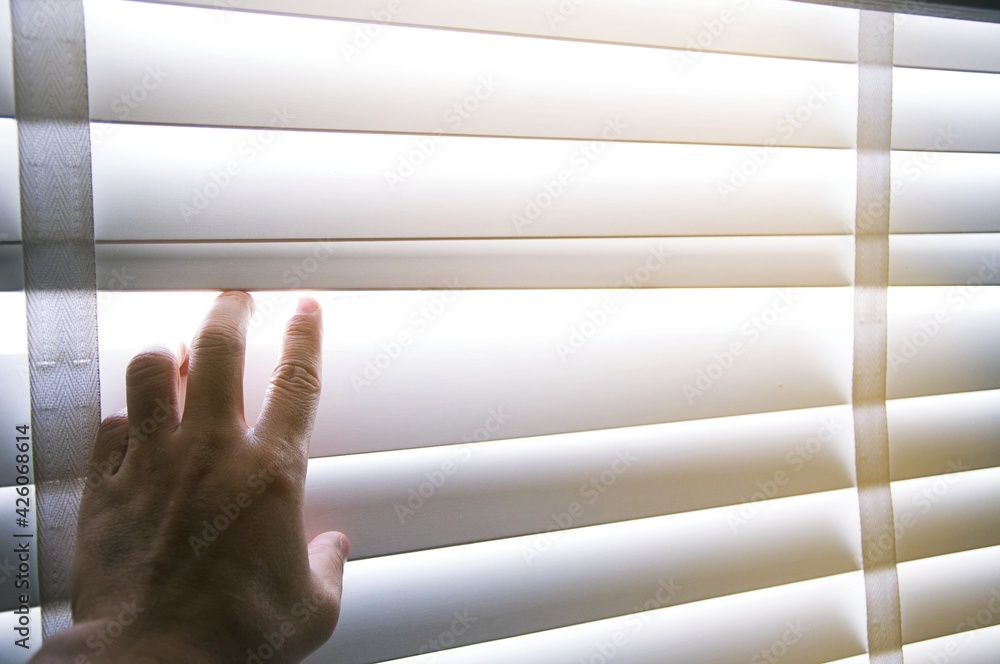 Windows jalousie. A man peeking through window blinds. Male hand ...