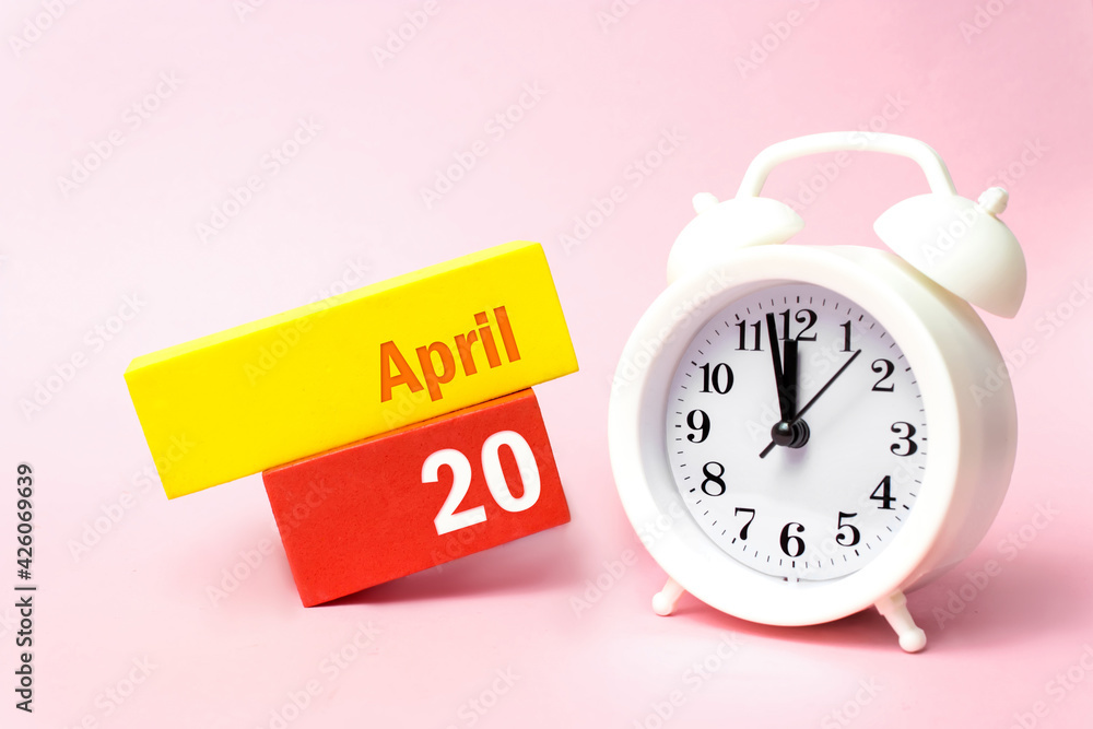 April 20th. Day 20 of month, Calendar date.White alarm clock on pastel ...