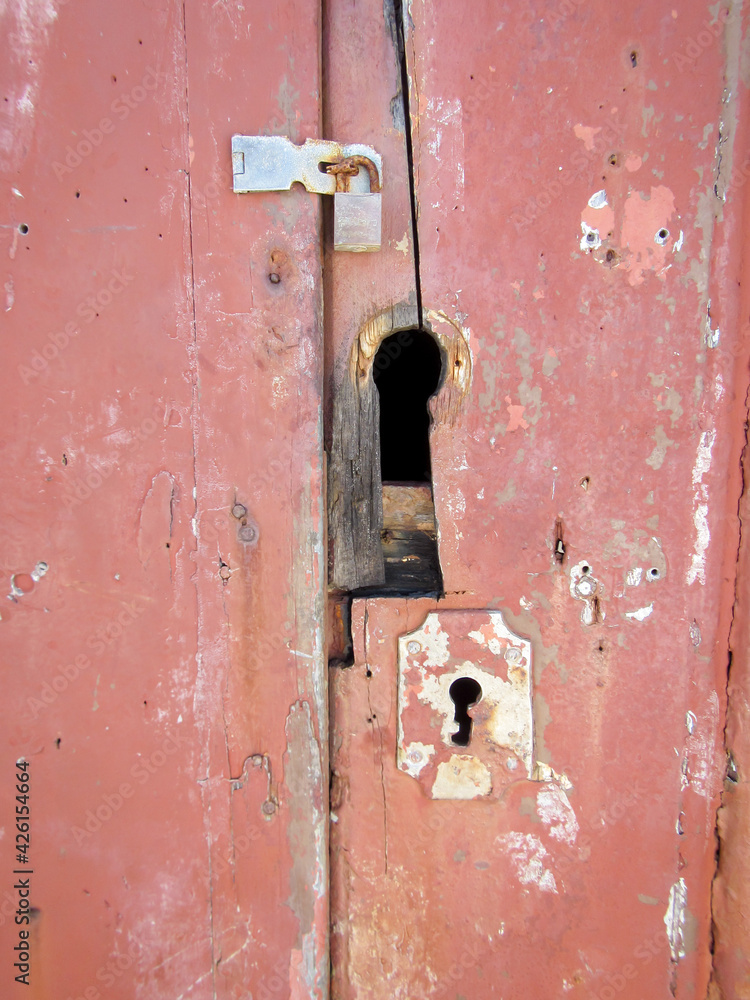 Broken rusty and deteriorated locks on an old wooden door from the 16th ...