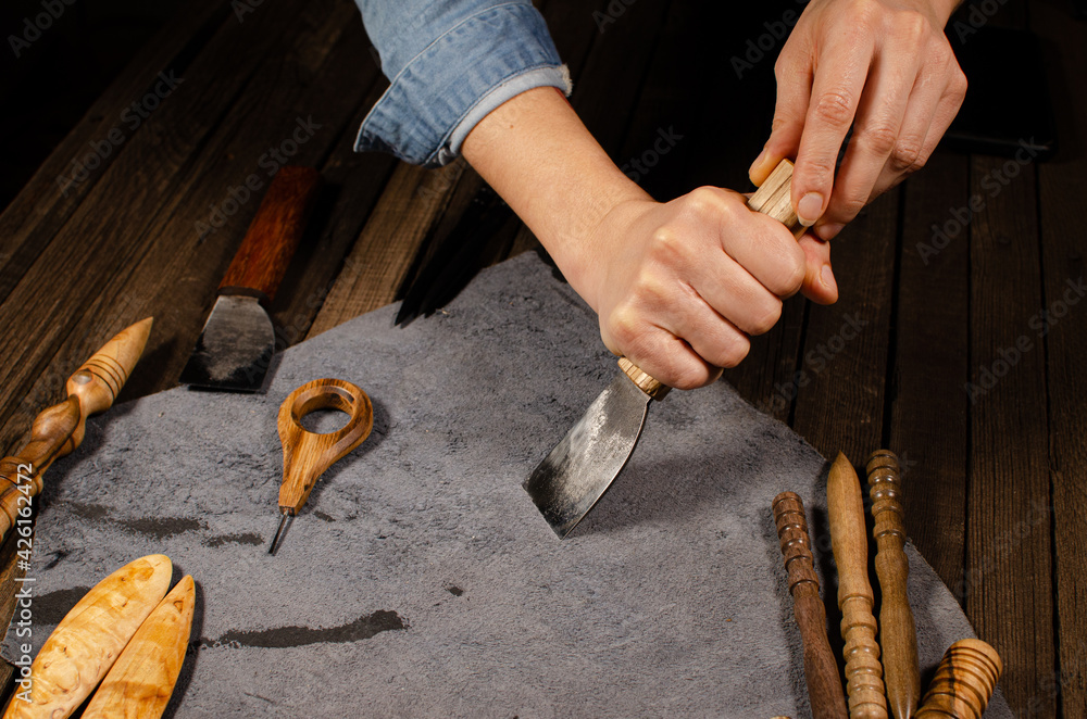 Foto de Tilt down of female shoemaker circling stencil lying on piece ...