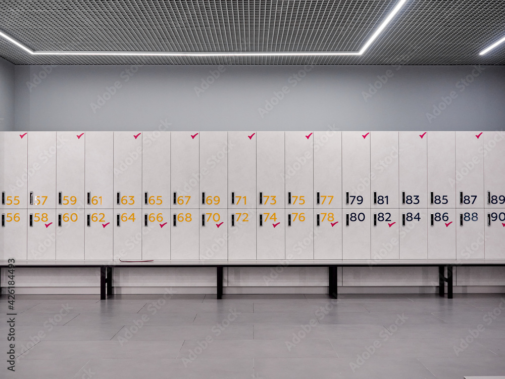 Modern dressing room in the gym. Two levels of lockers with electronic ...