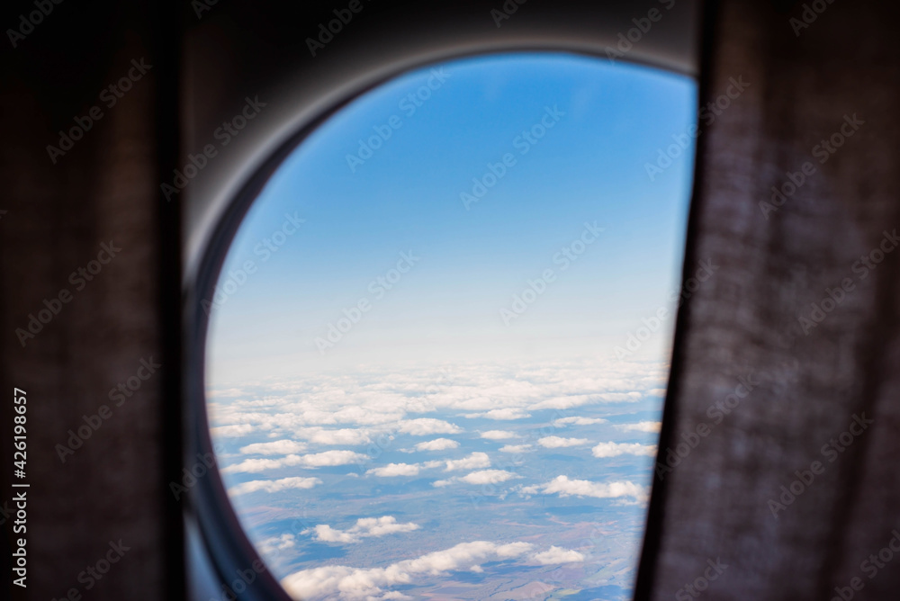 Aircraft illuminator window view on a clouds and terrain. Flight ...