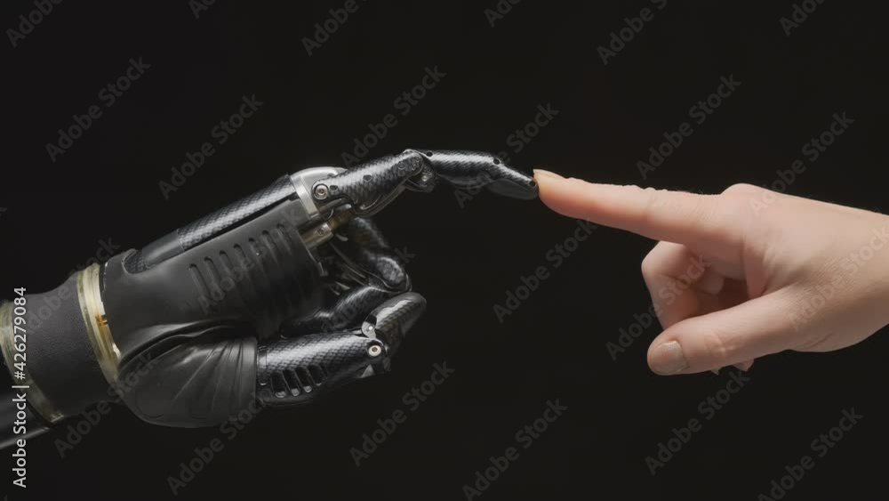 Humanoid robot arm and human hand reach out to each other and touch ...