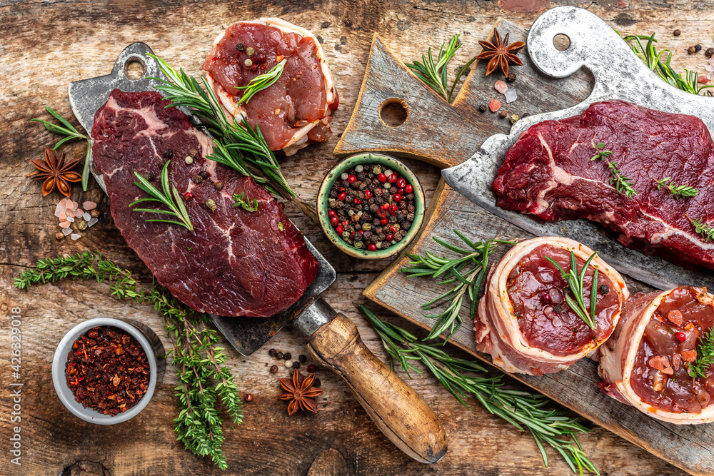 Variety of raw beef meat steaks for grilling with seasoning on over ...