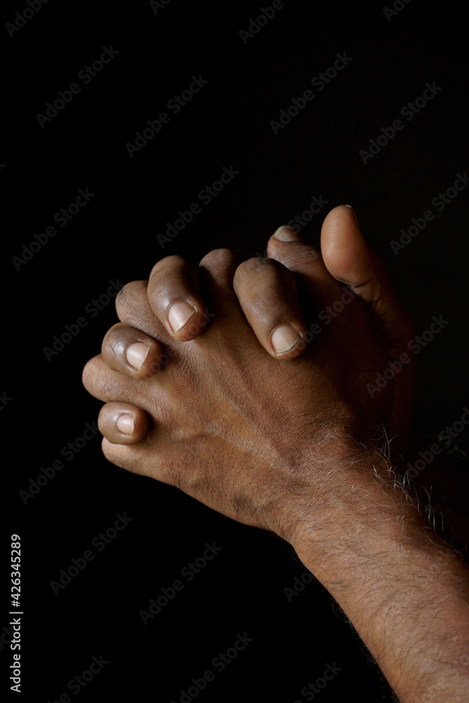 Praying hands of Indian Catholic man isolated on a black background ...