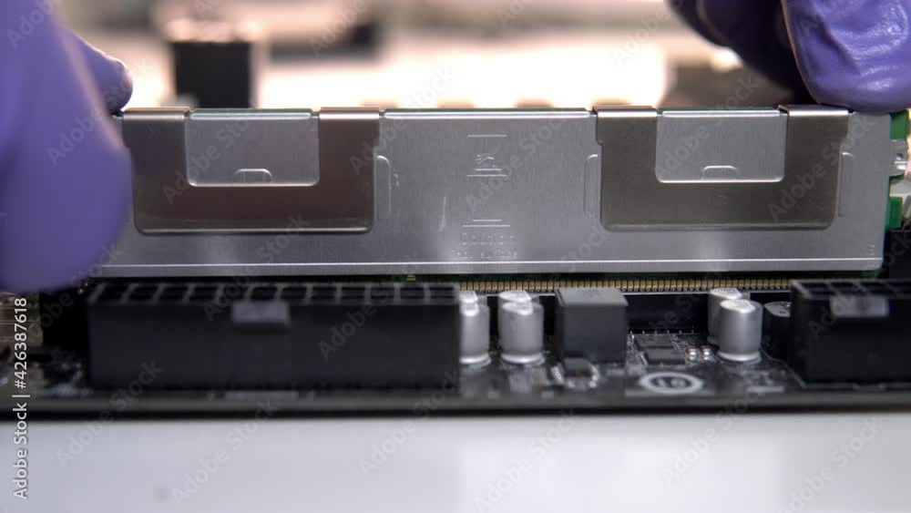 The repair technician inserts a RAM stick into the socket on the ...