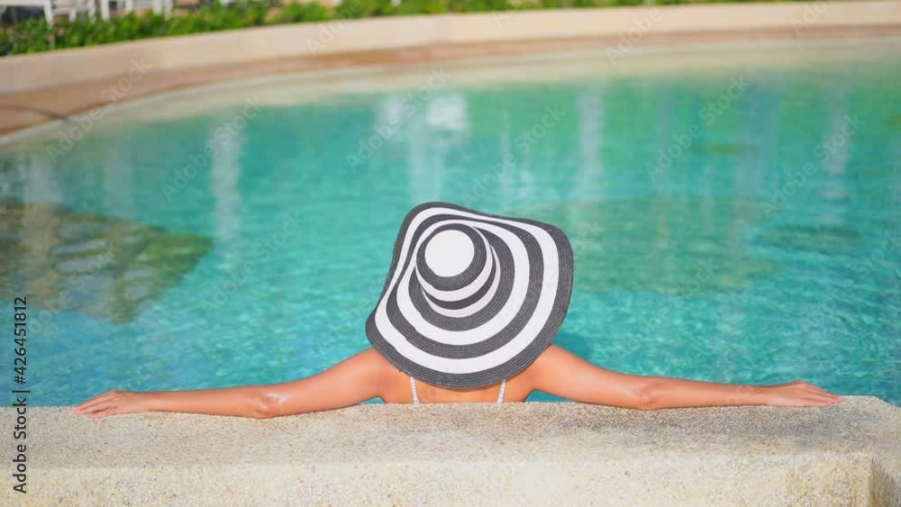 Back view of the lady in a swimming pool wearing a large black and ...