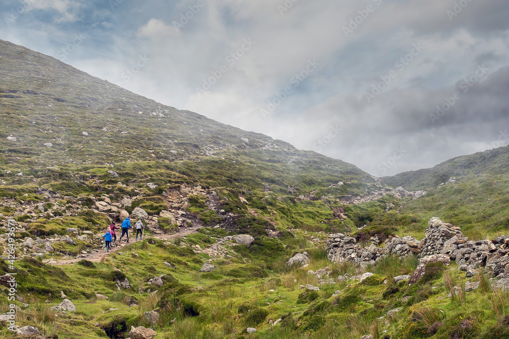 Family walking on a small path to the top of a mountain. Croagh Patrick ...