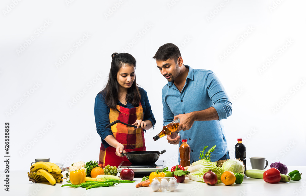 Indian couple cooking - Attractive wife and handsome husband in kitchen ...